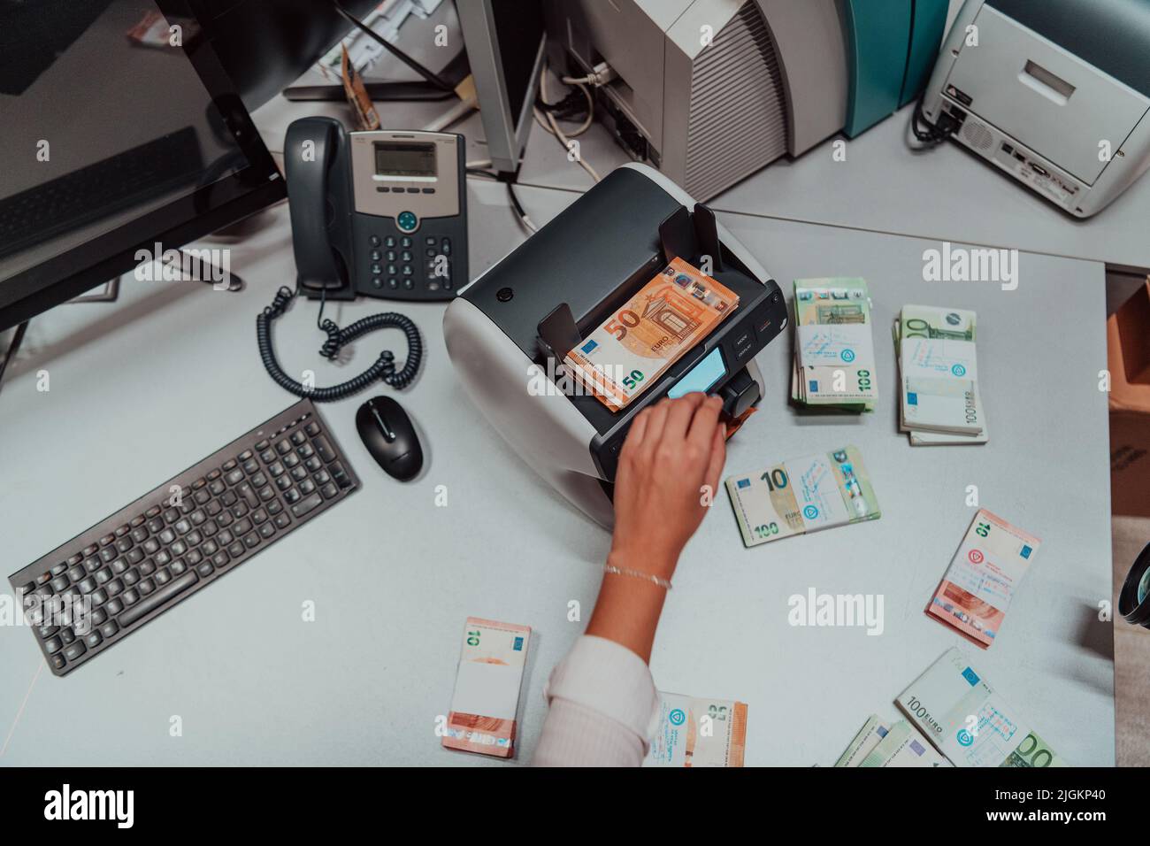 Bank employees using money counting machine while sorting and counting ...
