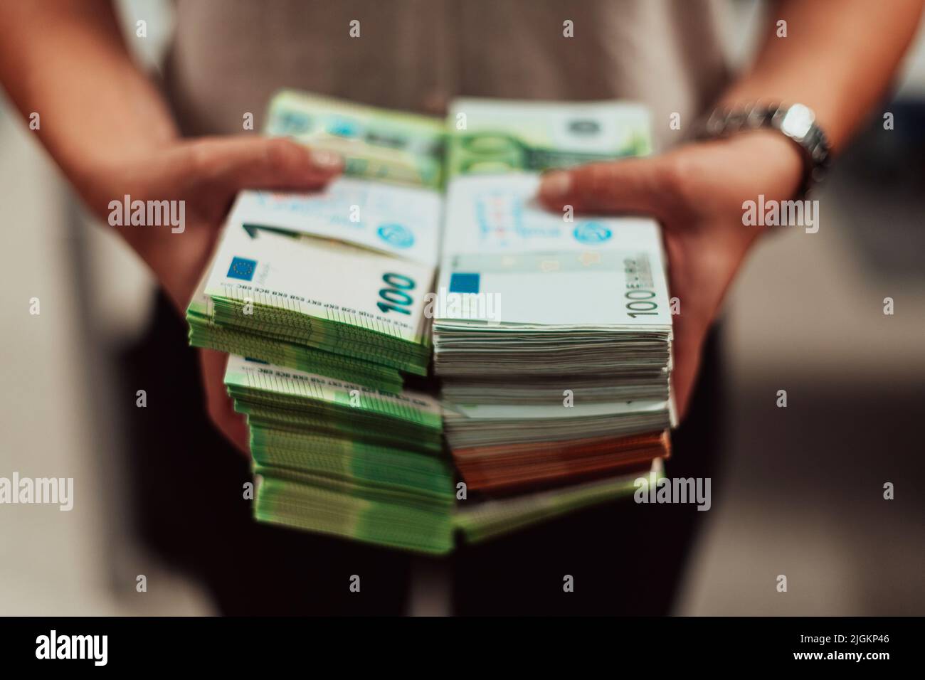 Bank employees holding a pile of paper banknotes while sorting and ...