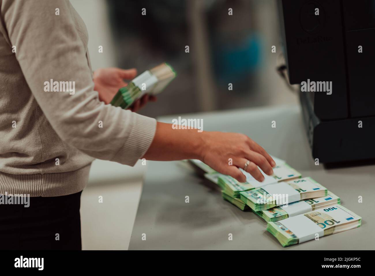 Bank employees holding a pile of paper banknotes while sorting and ...