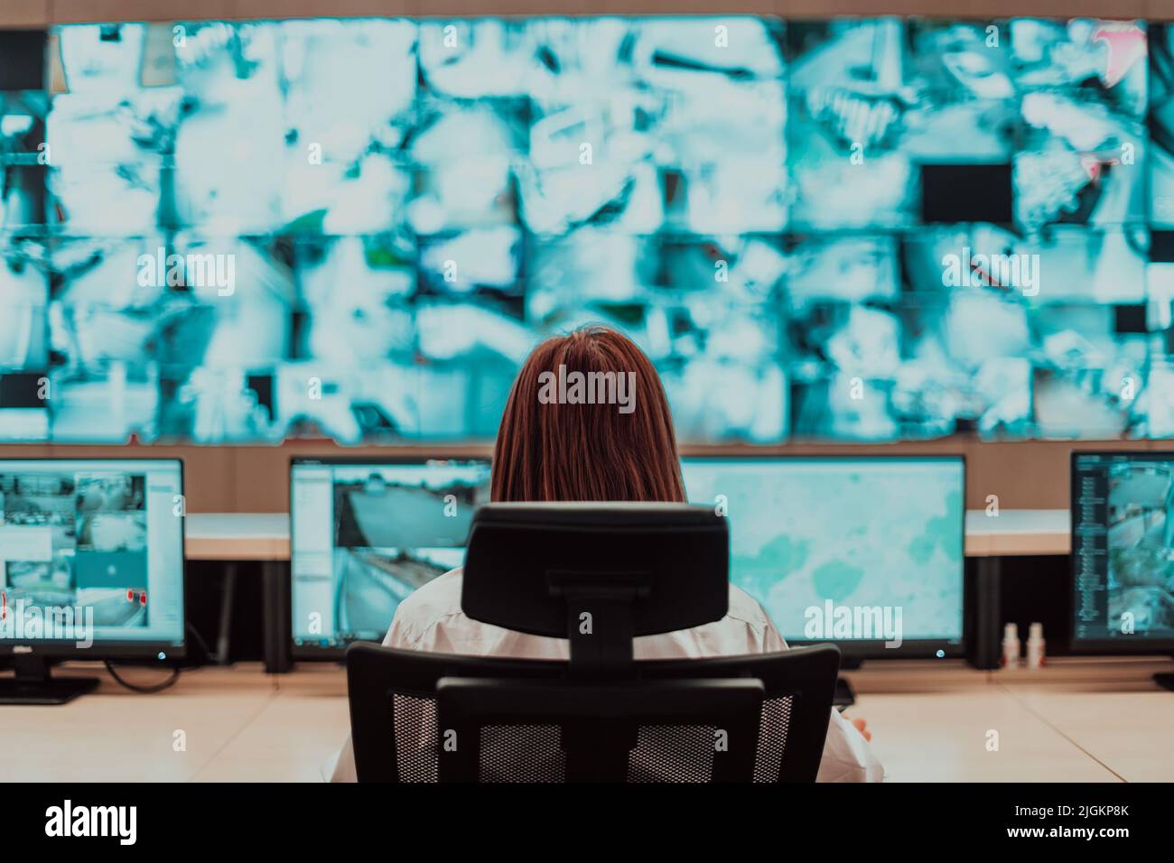 Female security operator working in a data system control room offices ...