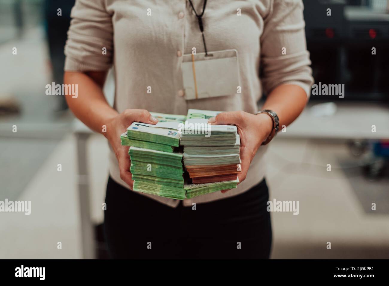 Bank employees holding a pile of paper banknotes while sorting and ...
