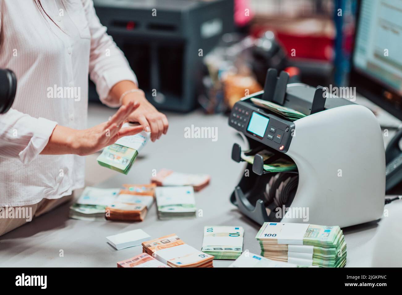 Bank employees using money counting machine while sorting and counting ...