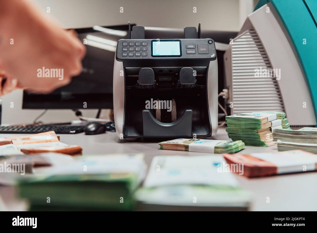 Bank employees using money counting machine while sorting and counting ...
