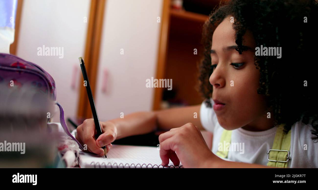 African ethnicity little girl doing homework studying. Mixed race child ...