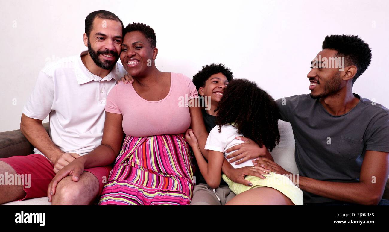 African family hugging in home sofa. Mixed race black parents and ...