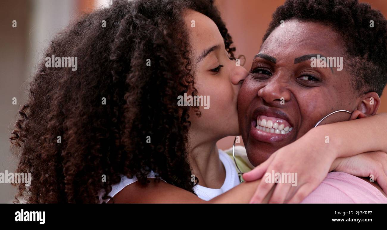 African mother cheek to cheek with daughter smiling Stock Photo - Alamy