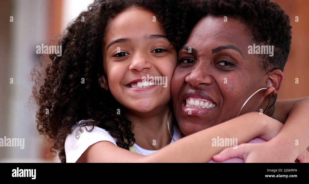 African mother cheek to cheek with daughter smiling Stock Photo - Alamy