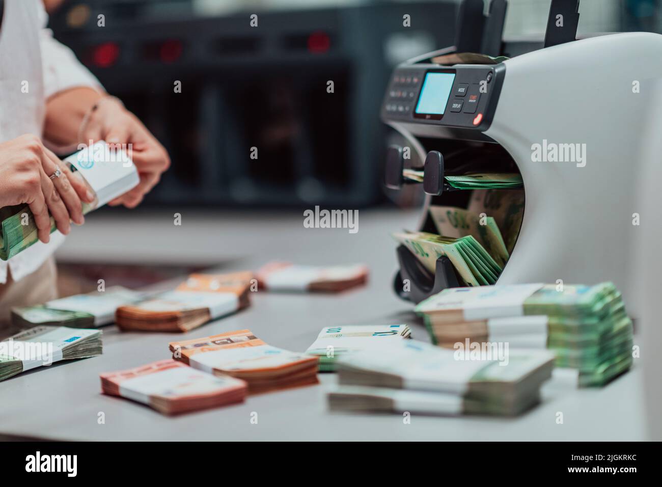 Bank employees using money counting machine while sorting and counting ...
