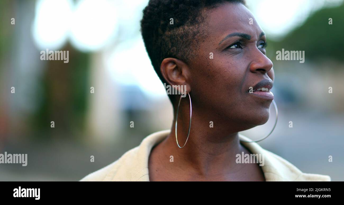 Anxious African woman walking outside. Black person ruminating thoughts ...