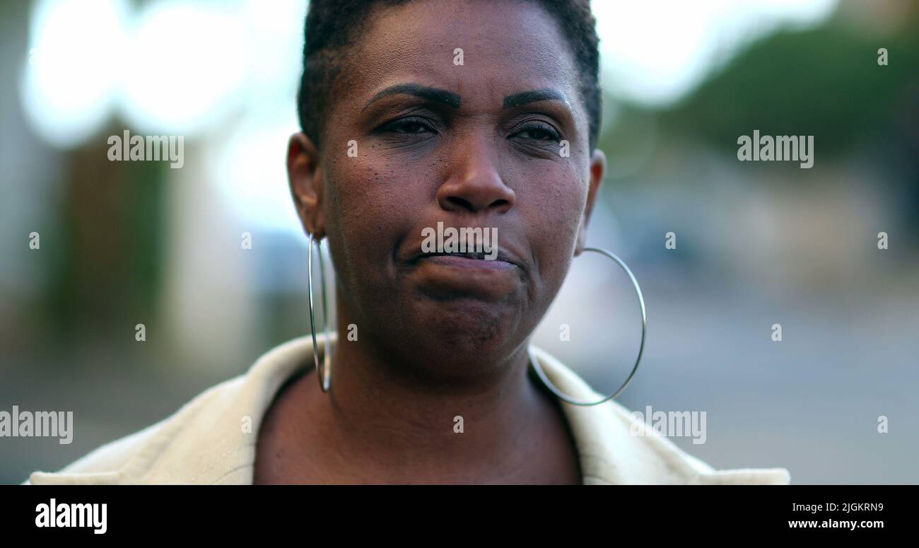 Anxious African woman walking outside. Black person ruminating thoughts ...