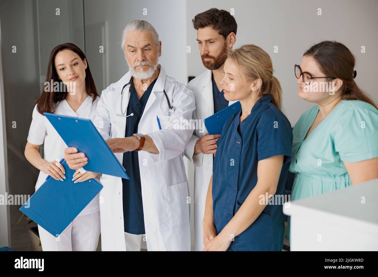 Doctor giving lecture to interns in hospital discussing patient ...