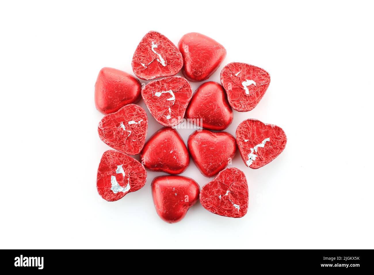 Group of heart shaped chocolate candies wrapped in red foil isolated on ...