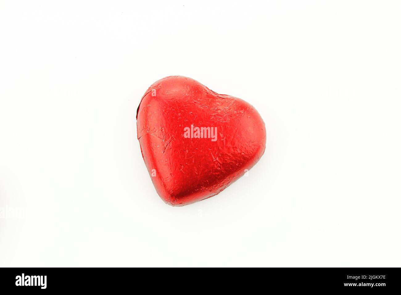 Heart shaped chocolate candy in wrapped in red foil isolated on white ...