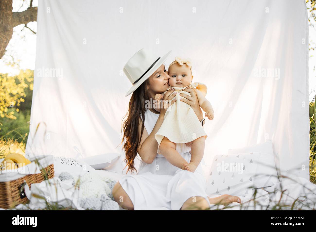 Young mother resting with her daughter while holding her in hands in ...