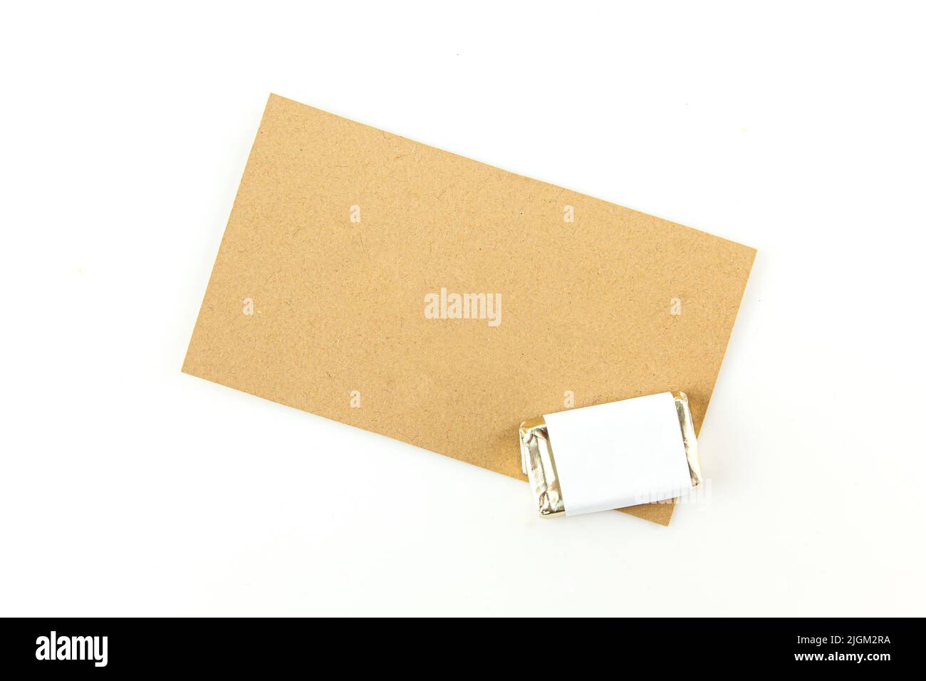 Blank carton paper card with small wrapped in foil candy isolated on ...
