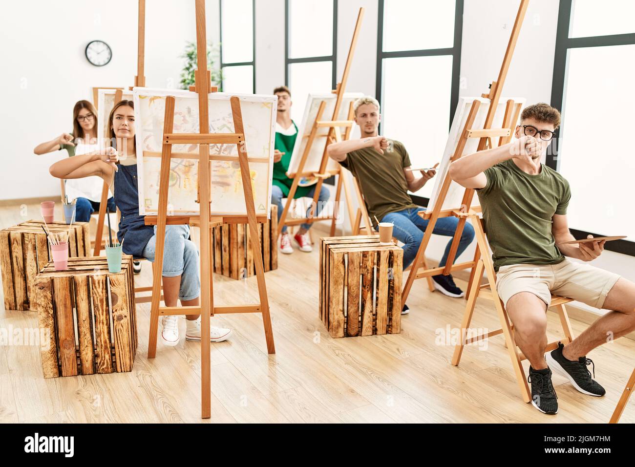 Group of young people drawing at art studio with angry face, negative ...