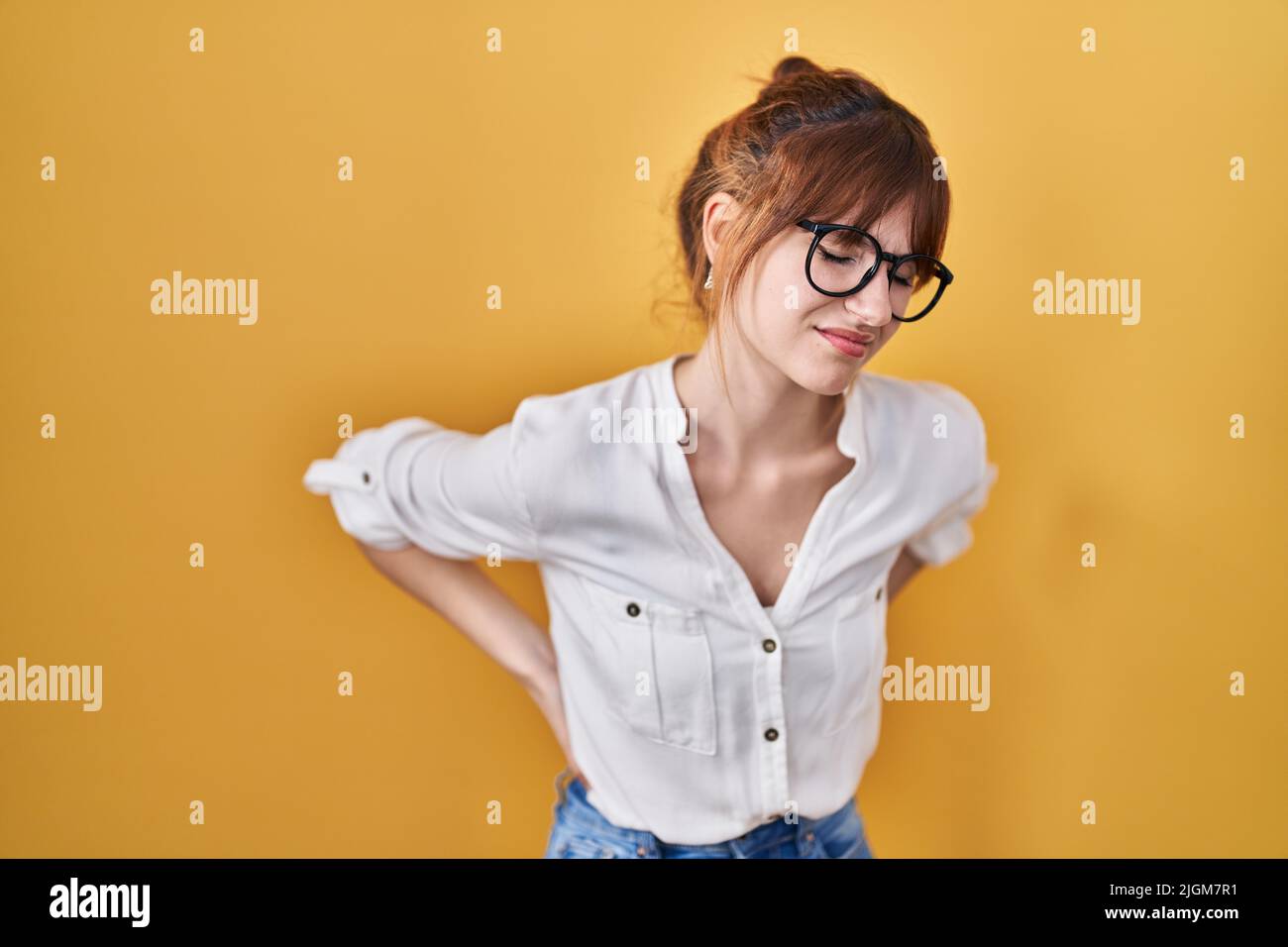 Young beautiful woman wearing casual shirt over yellow background ...