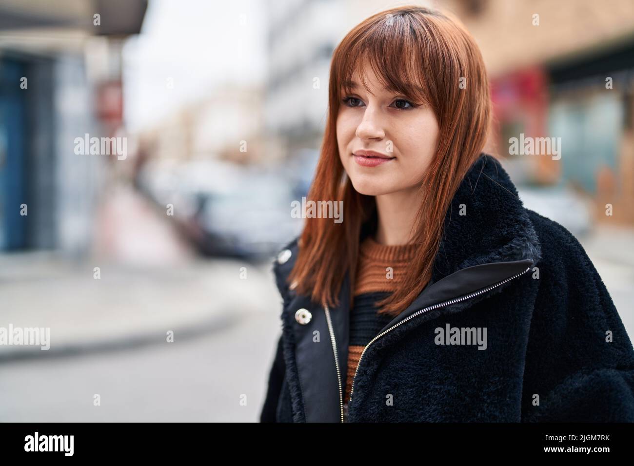 Young woman with relaxed expression standing at street Stock Photo - Alamy