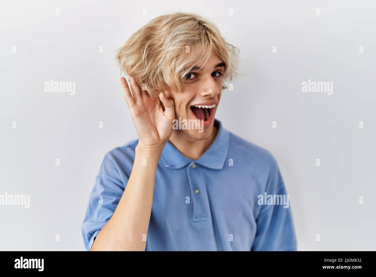 Young modern man standing over isolated background smiling with hand ...