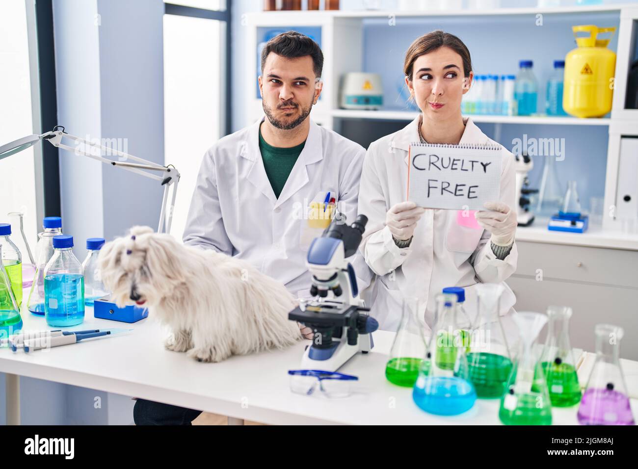 Young hispanic people working at scientist laboratory with dog smiling ...