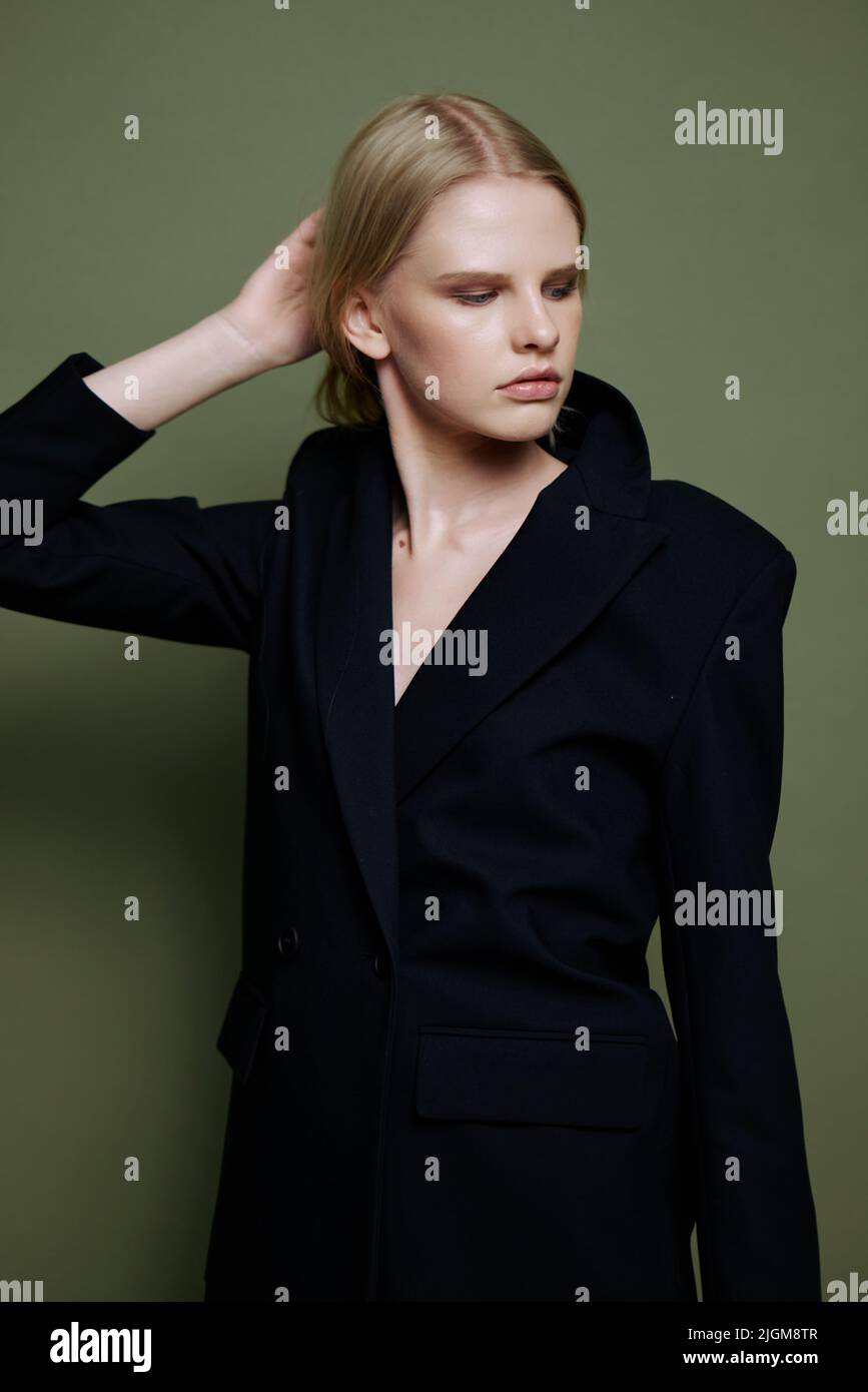 An elegant lady looks to the side posing in isolation on a green ...