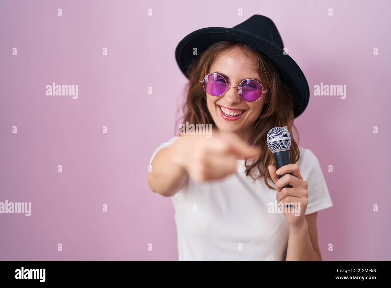 Beautiful brunette woman singing song using microphone smiling happy ...