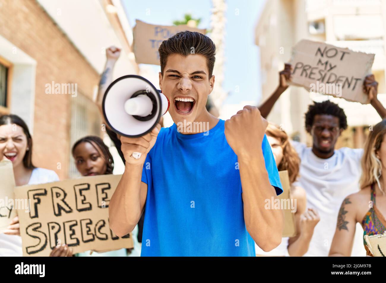 Group of young activists protesting holding banner and using megaphone ...