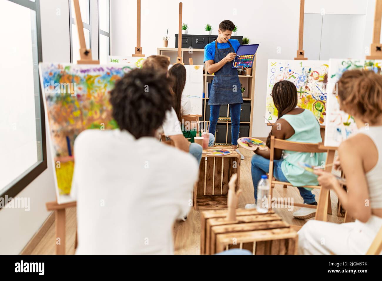 Group of people smiling happy drawing in paint class at art studio ...