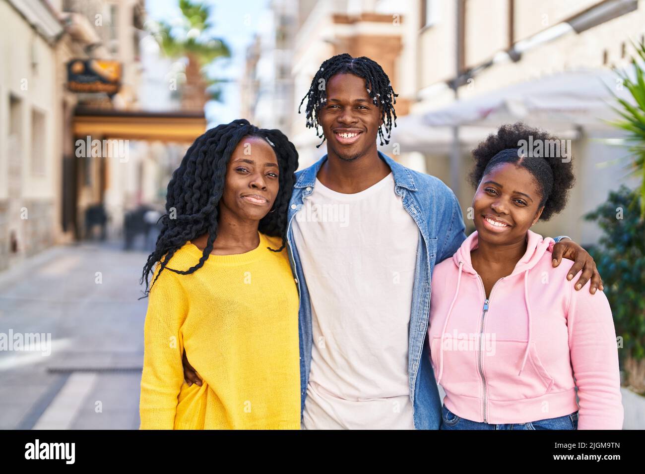 African american friends smiling confident hugging each other at street ...