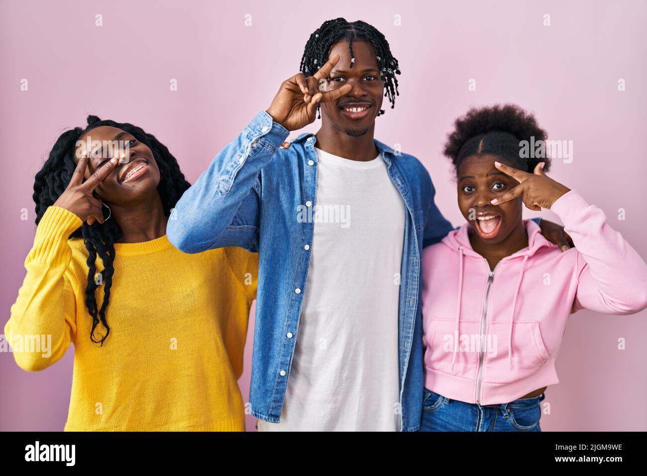 Group of three young black people standing together over pink ...