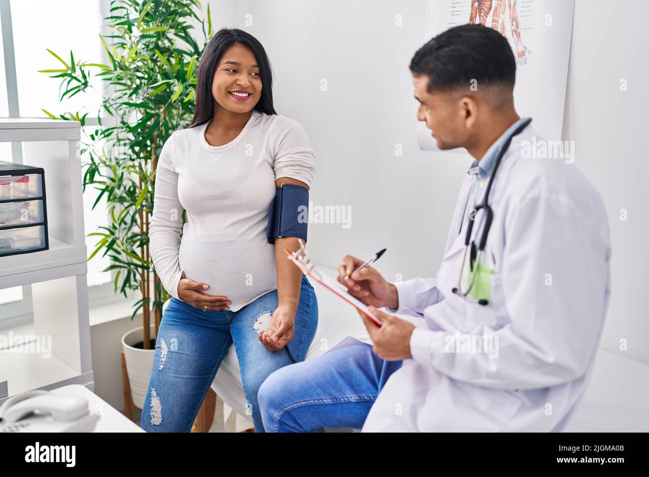 Young latin couple doctor and patient using tensiometer at clinic Stock ...