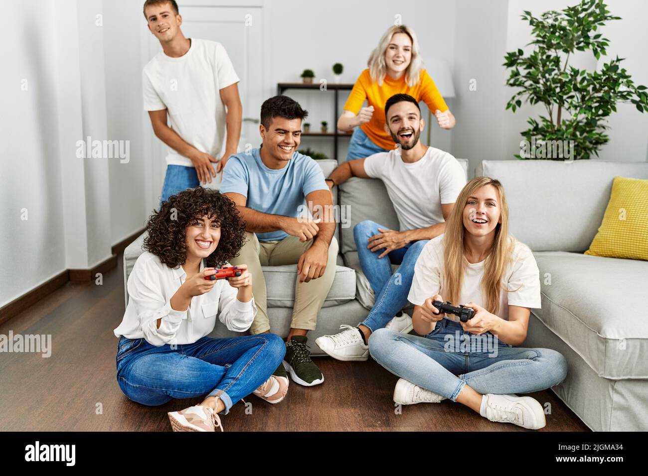 Group of young friends smiling happy playing video game at home Stock ...