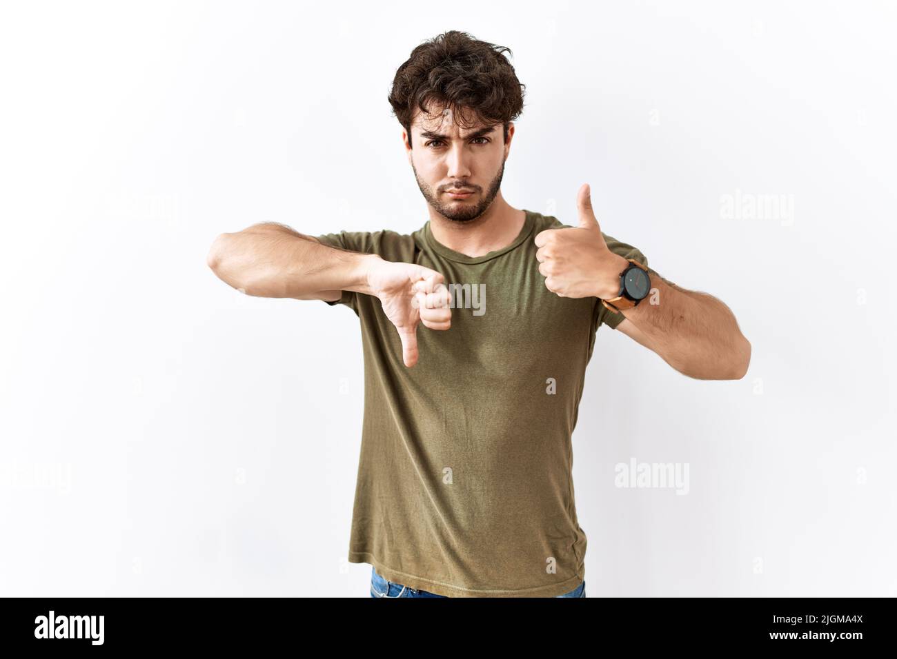 Hispanic man standing over isolated white background doing thumbs up ...