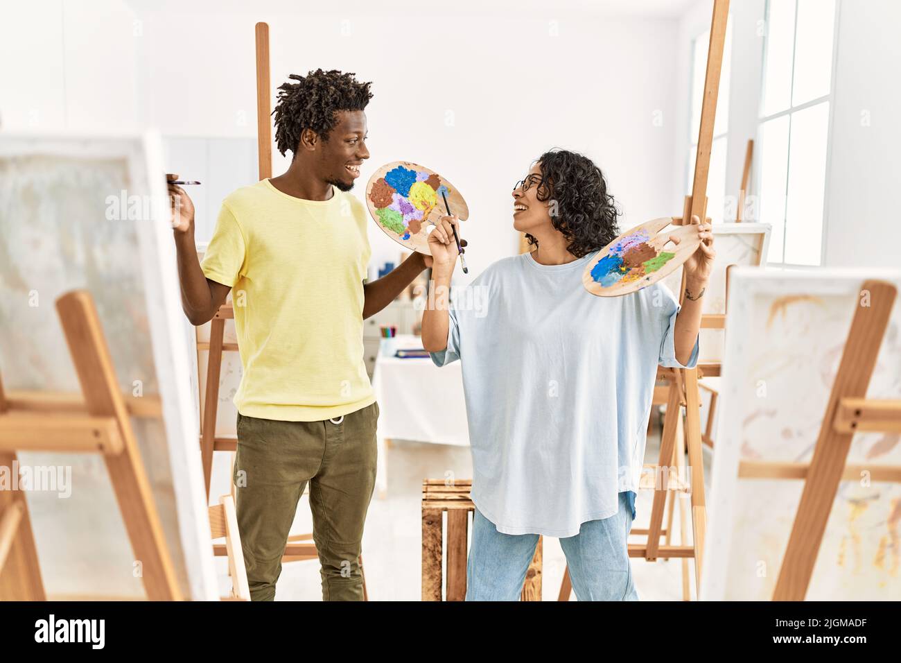 African american artist couple smiling happy holding paintbrush and ...