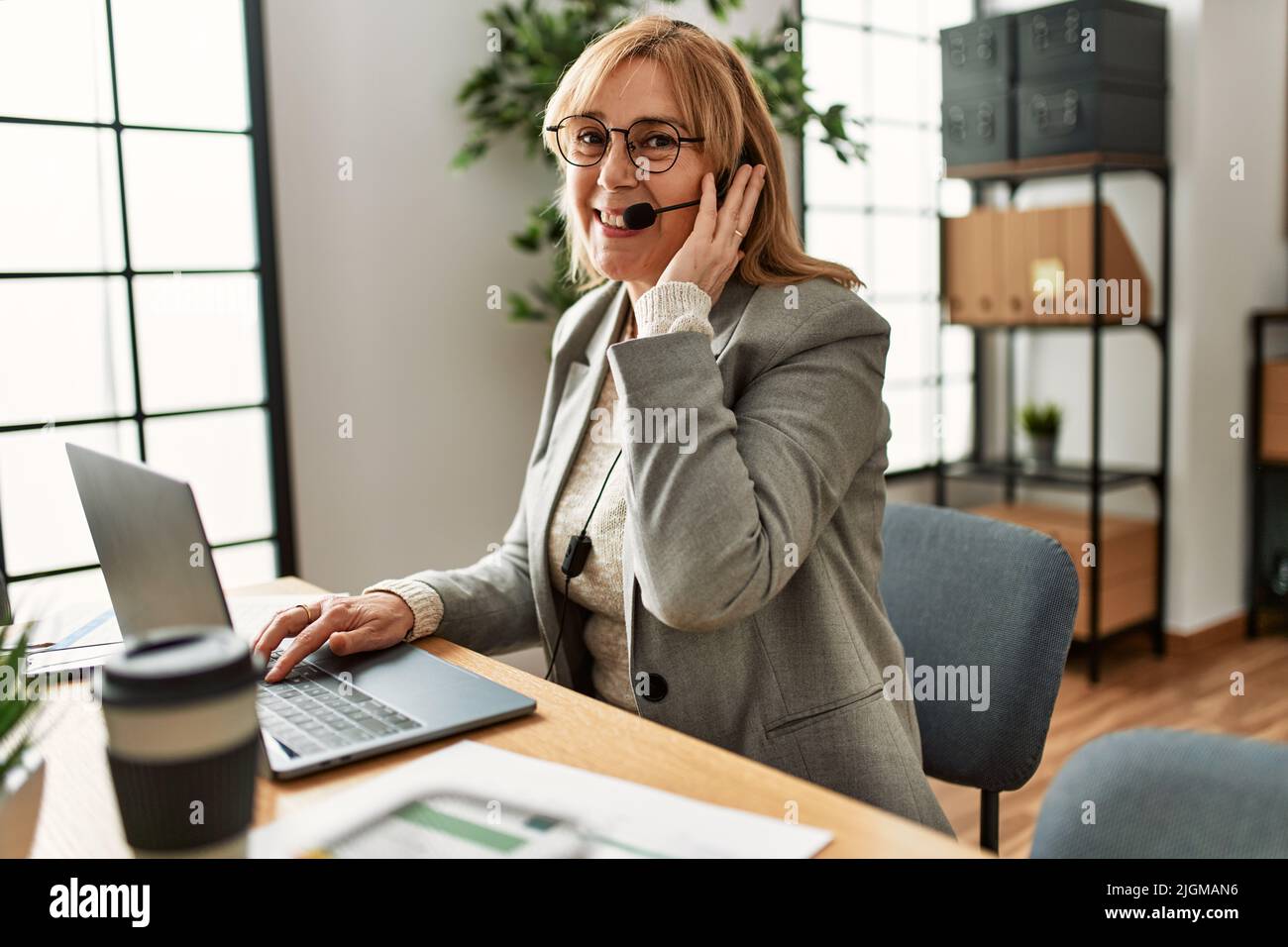 Middle age call center agent working at the office Stock Photo - Alamy