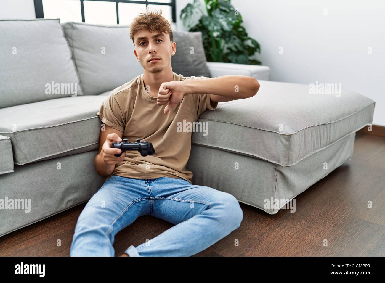 Young caucasian man playing video game holding controller at home with ...