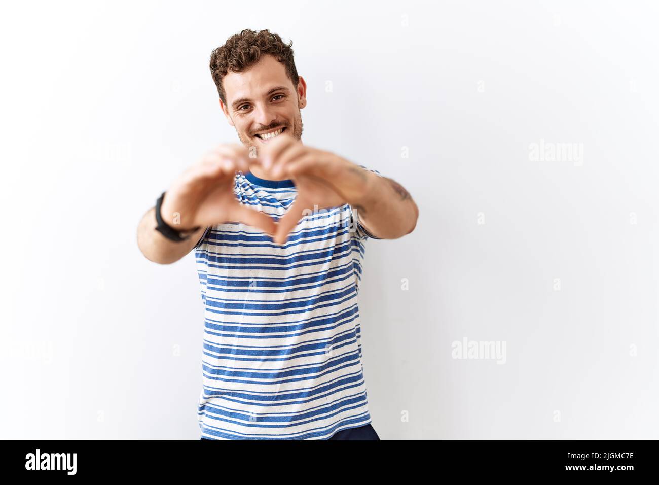 Handsome young man standing over isolated background smiling in love ...