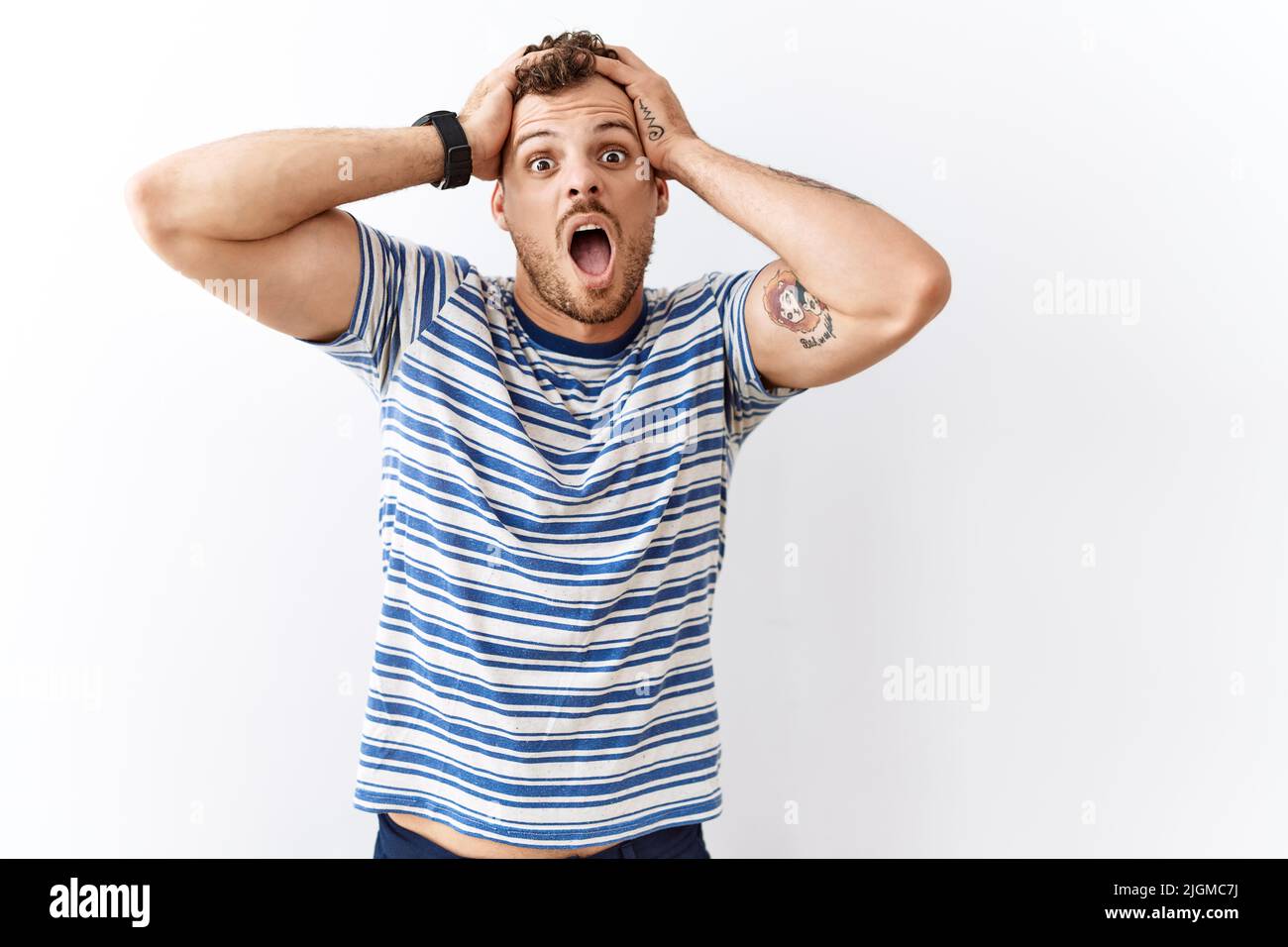 Handsome young man standing over isolated background crazy and scared ...