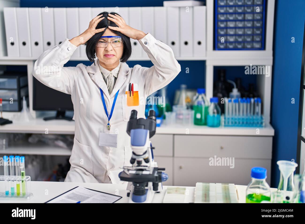Young asian woman working at scientist laboratory suffering from ...