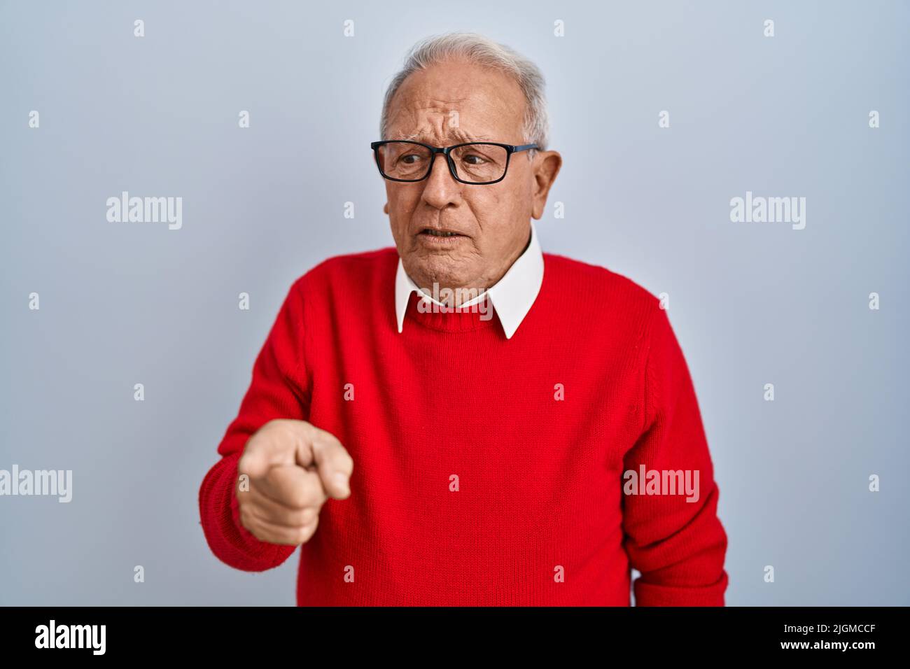Senior man with grey hair standing over isolated background pointing ...