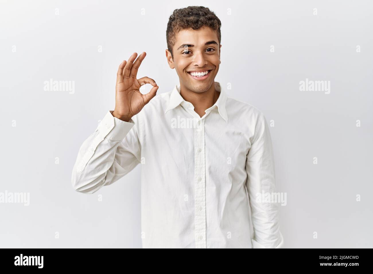 Young handsome hispanic man standing over isolated background smiling ...