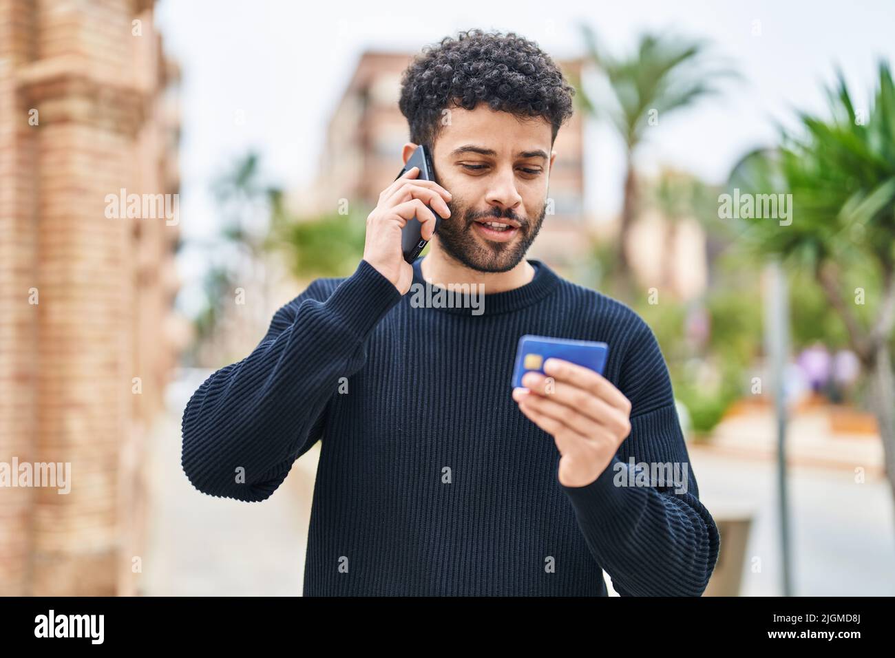 Young arab man using smartphone and credit card at street Stock Photo ...