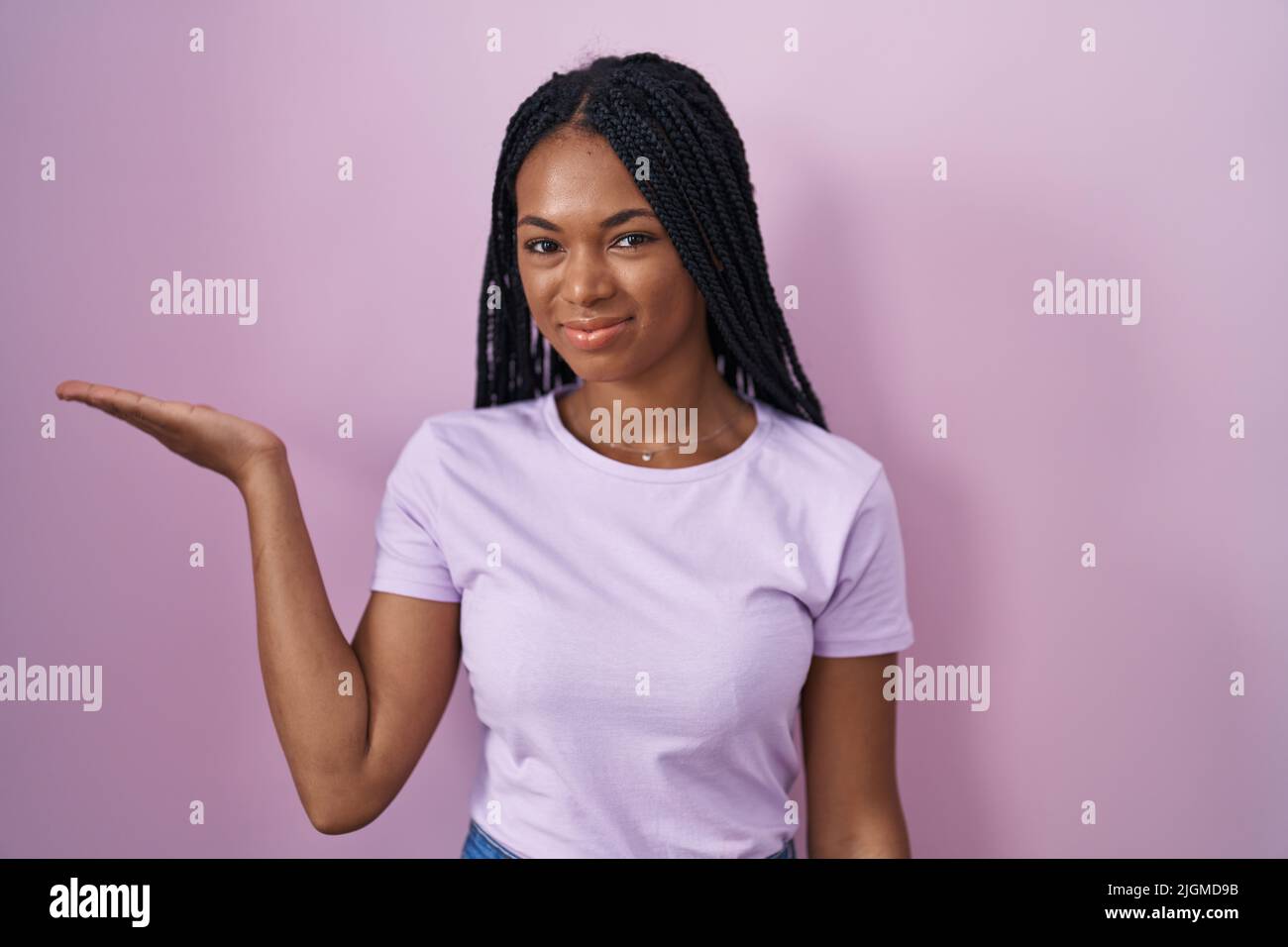 African american woman with braids standing over pink background ...