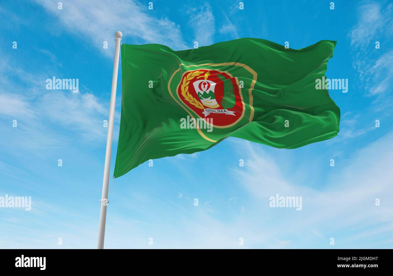 official flag of Maluku Indonesia at cloudy sky background on sunset ...