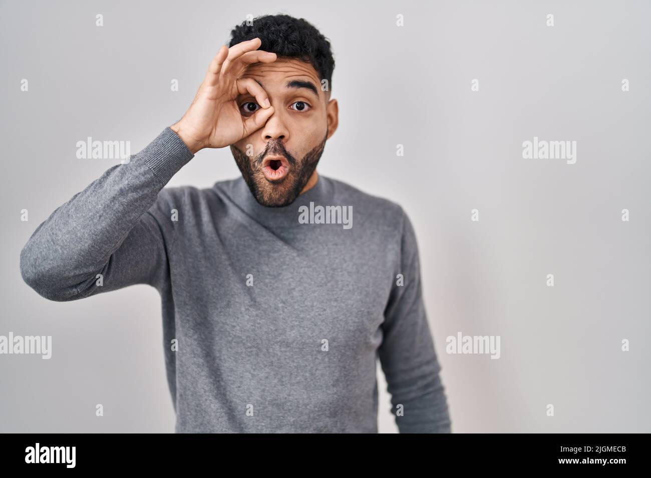 Hispanic man with beard standing over white background doing ok gesture ...