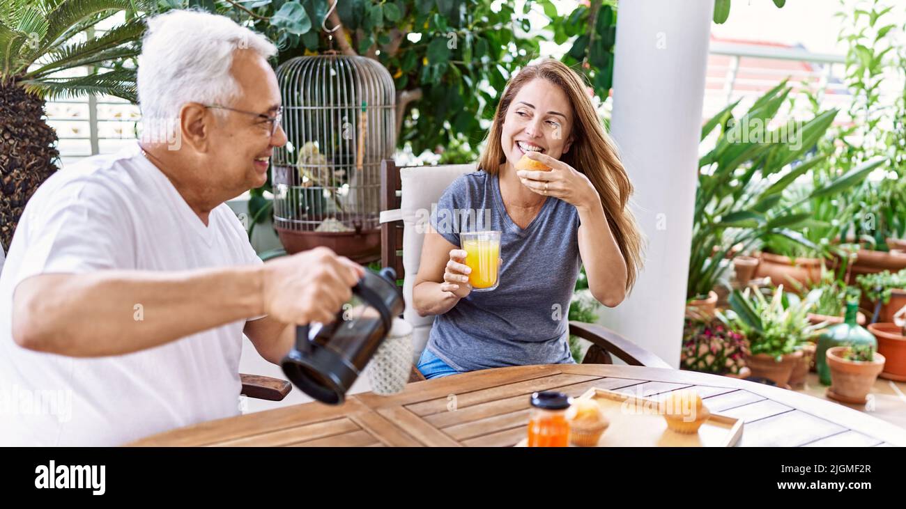 Middle age hispanic couple smiling happy having breakfast at the ...