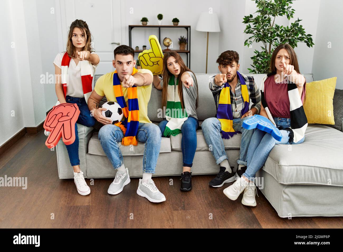 Group of young people watching football game wearing team scarf ...