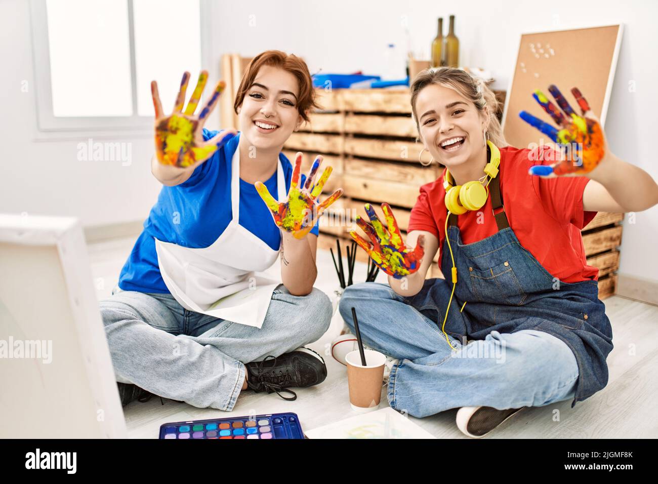 Two artist student women smiling happy showing painted hands at art ...