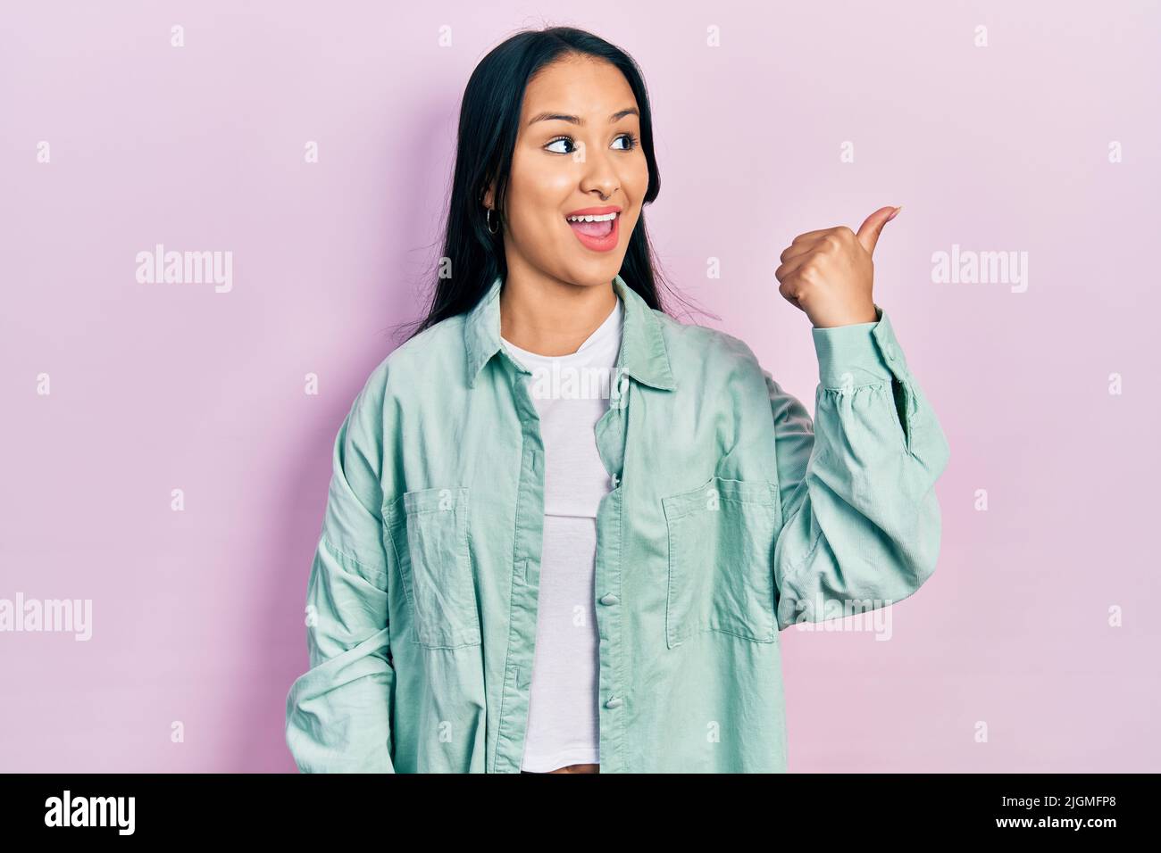 Beautiful hispanic woman with nose piercing wearing casual green jacket ...