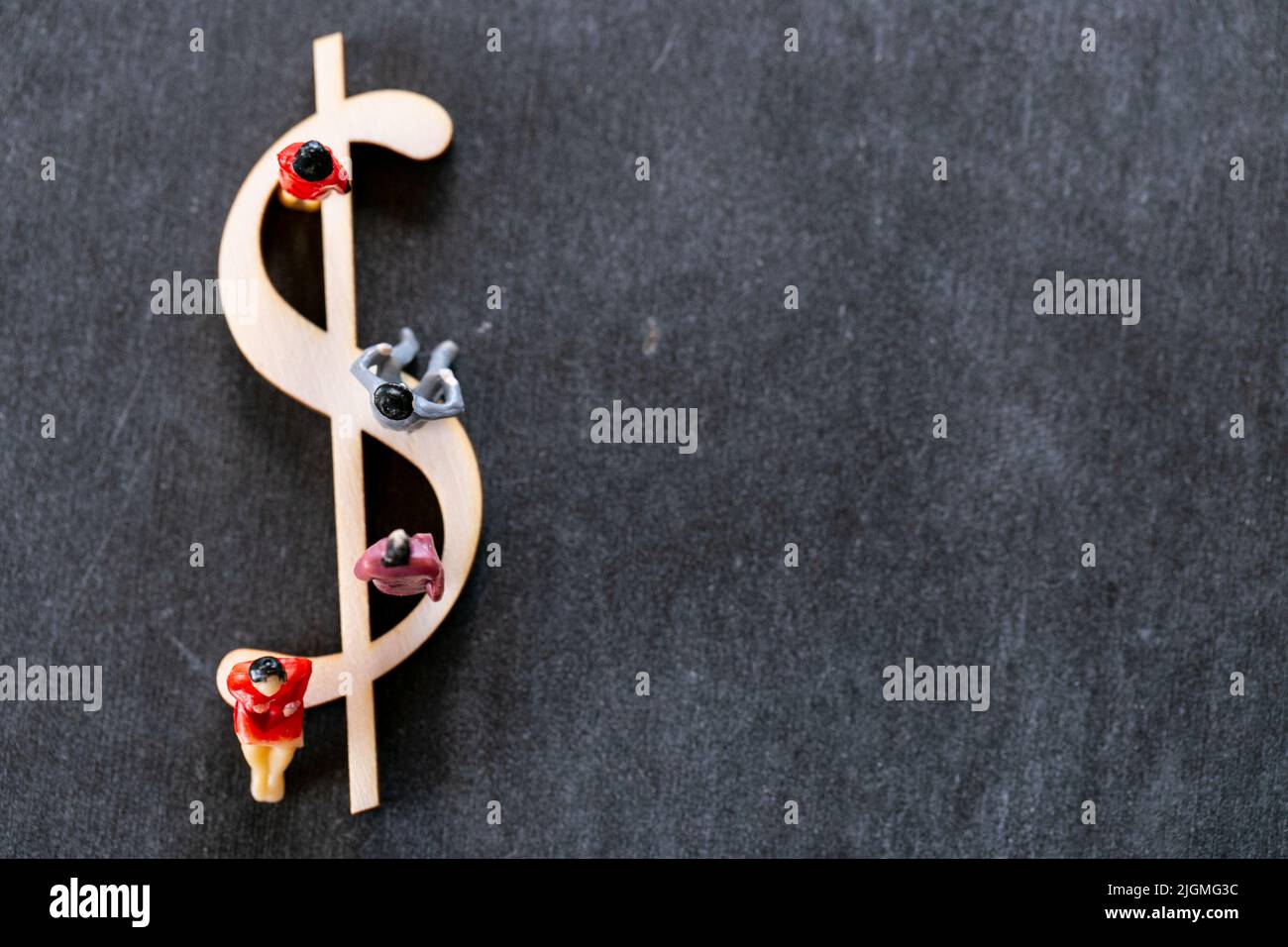Dollar inflation.Dollar sign and figurines of people on a black ...
